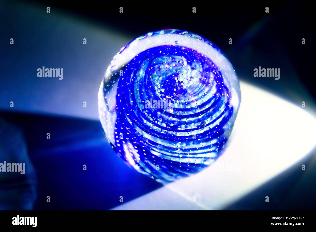 A transparent glass ball with inclusions casts real shadows on a white ...