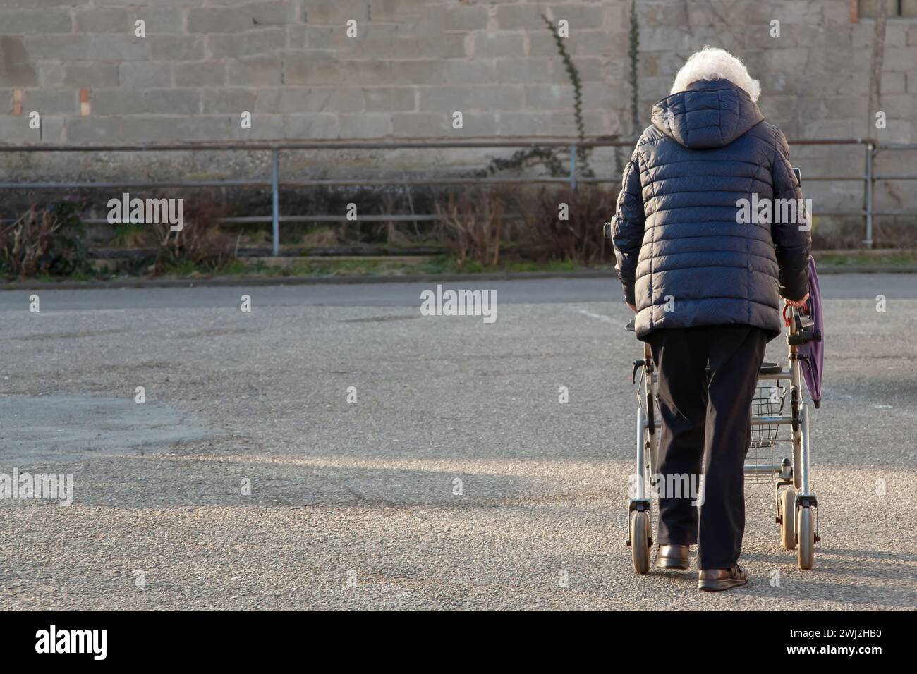 Old lady, senior woman with rollator for a walk on the street. Grandma ...