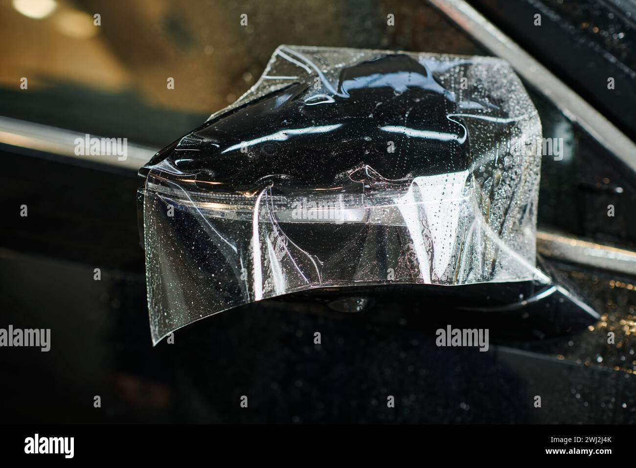 object photo of side view mirror of black new auto with partially ...