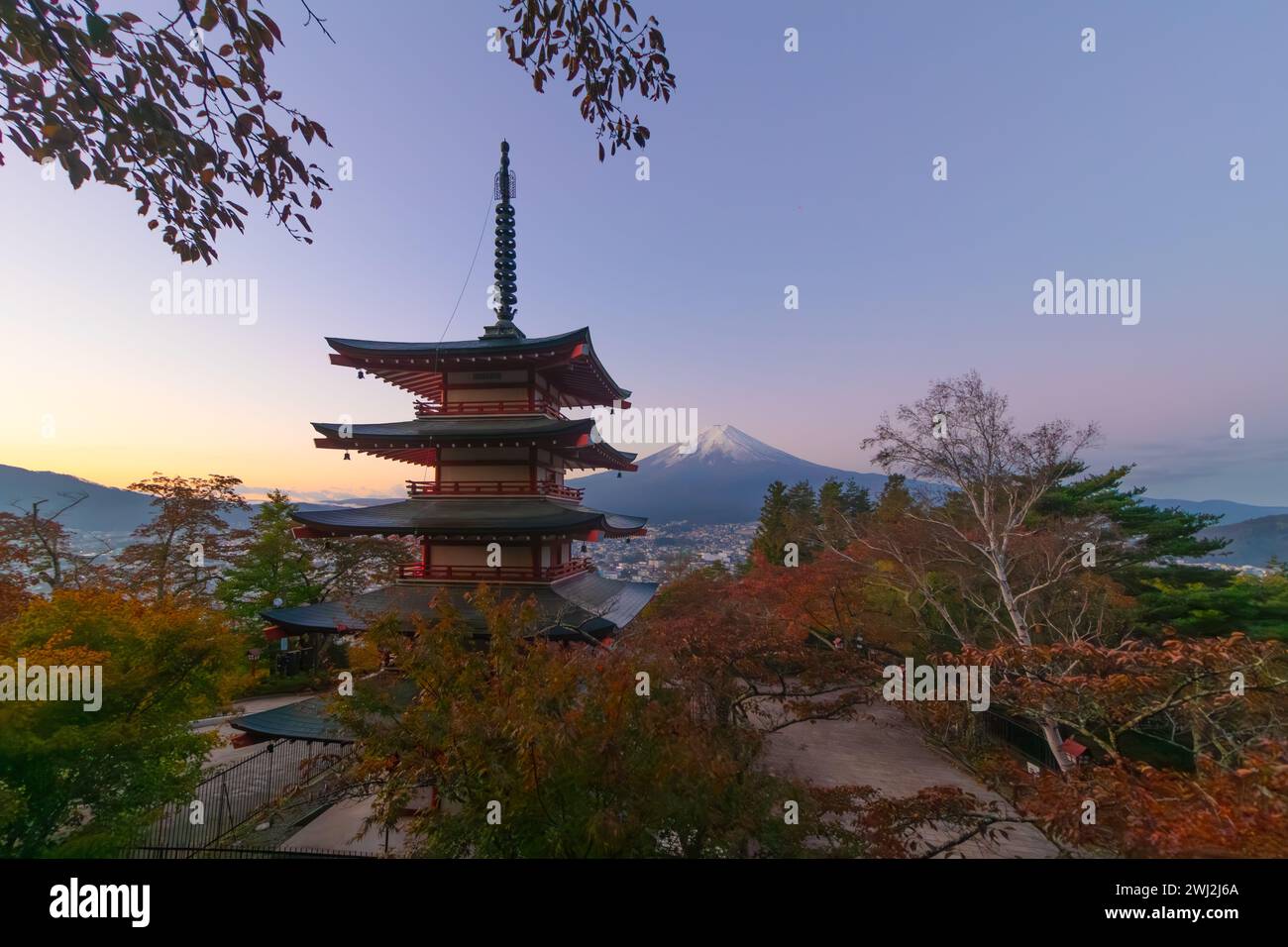 Sunset over Mount Fuji with a beautiful building surrounded by trees in ...