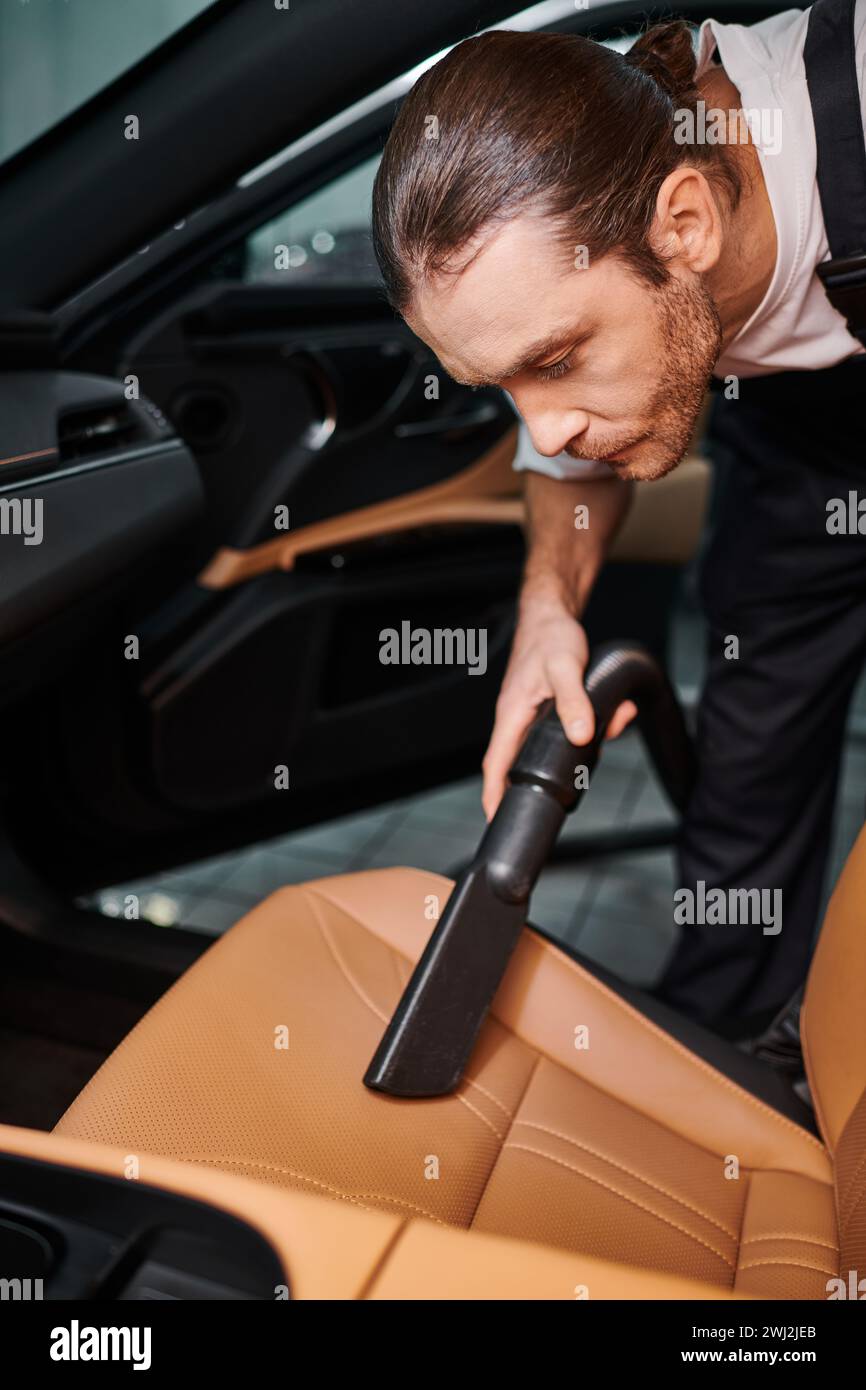 good looking hard working serviceman in uniform using manual vacuum ...