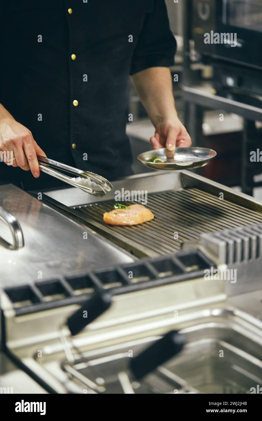 Chef in the Kitchen of the Restaurant prepares dishes for serving to ...