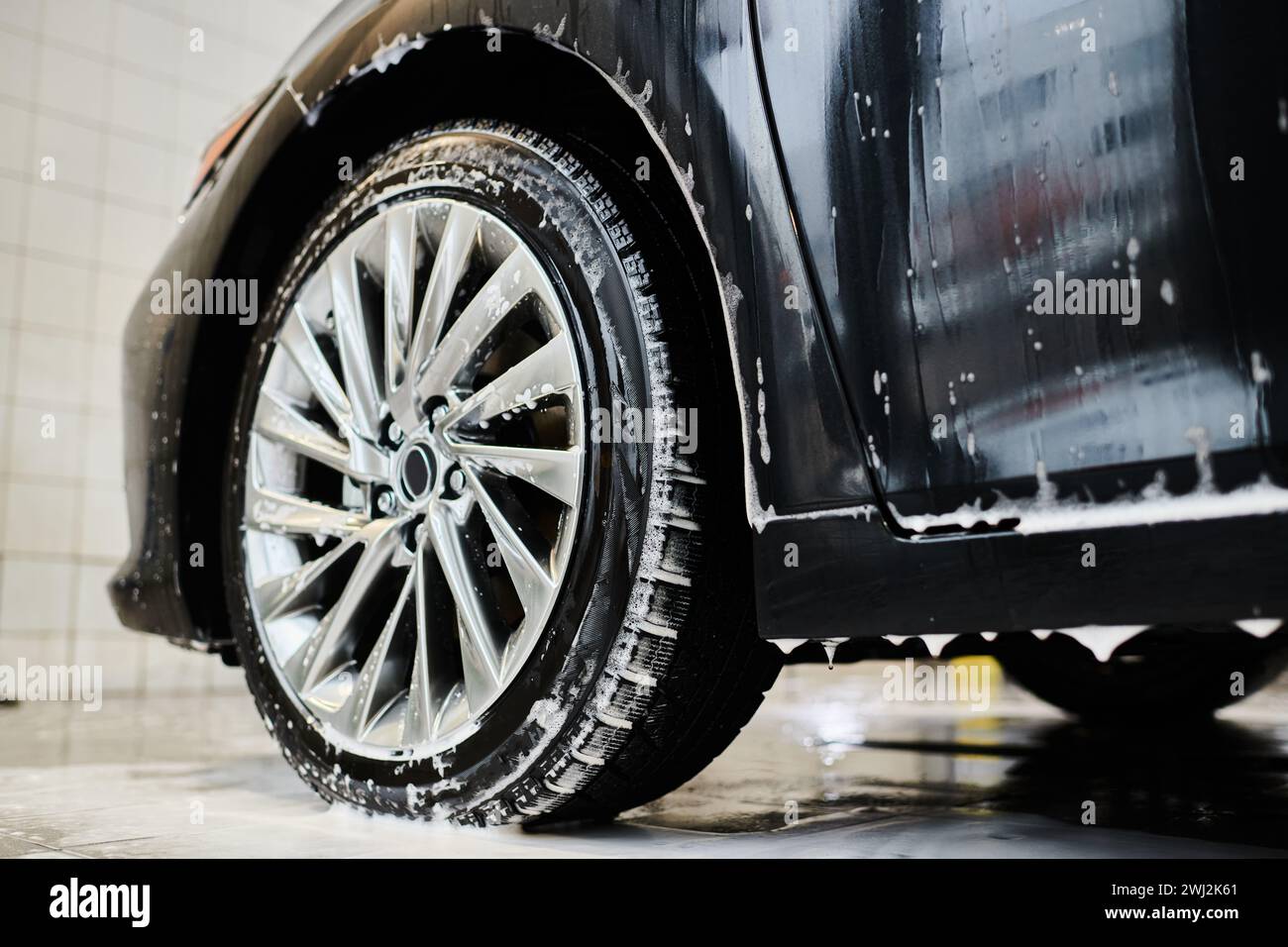 object photo of shining tired of black modern auto covered with soap ...