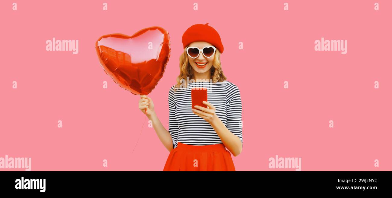 pretty happy smiling young woman with mobile phone and red heart shaped ...