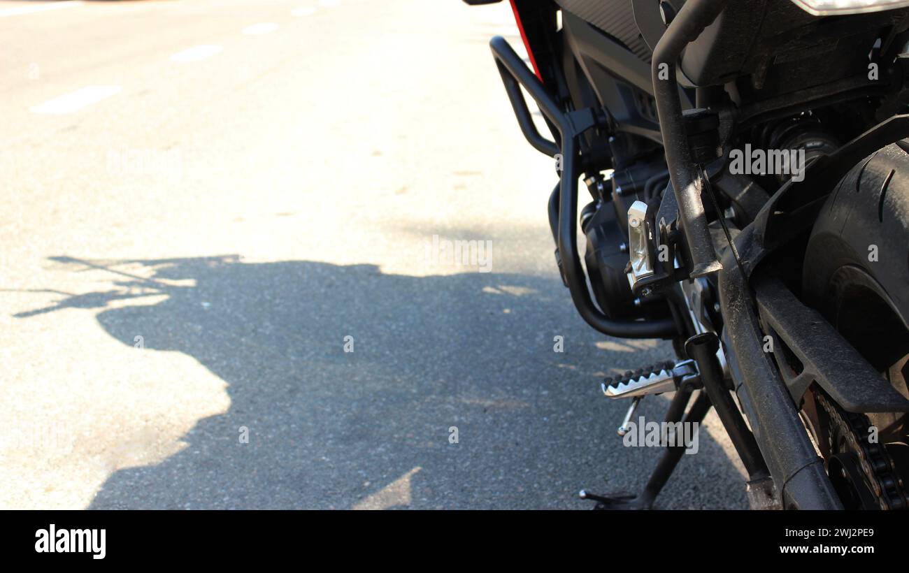 Motorcycle on a kickstand casts a shadow on asphalt road detailed stock ...
