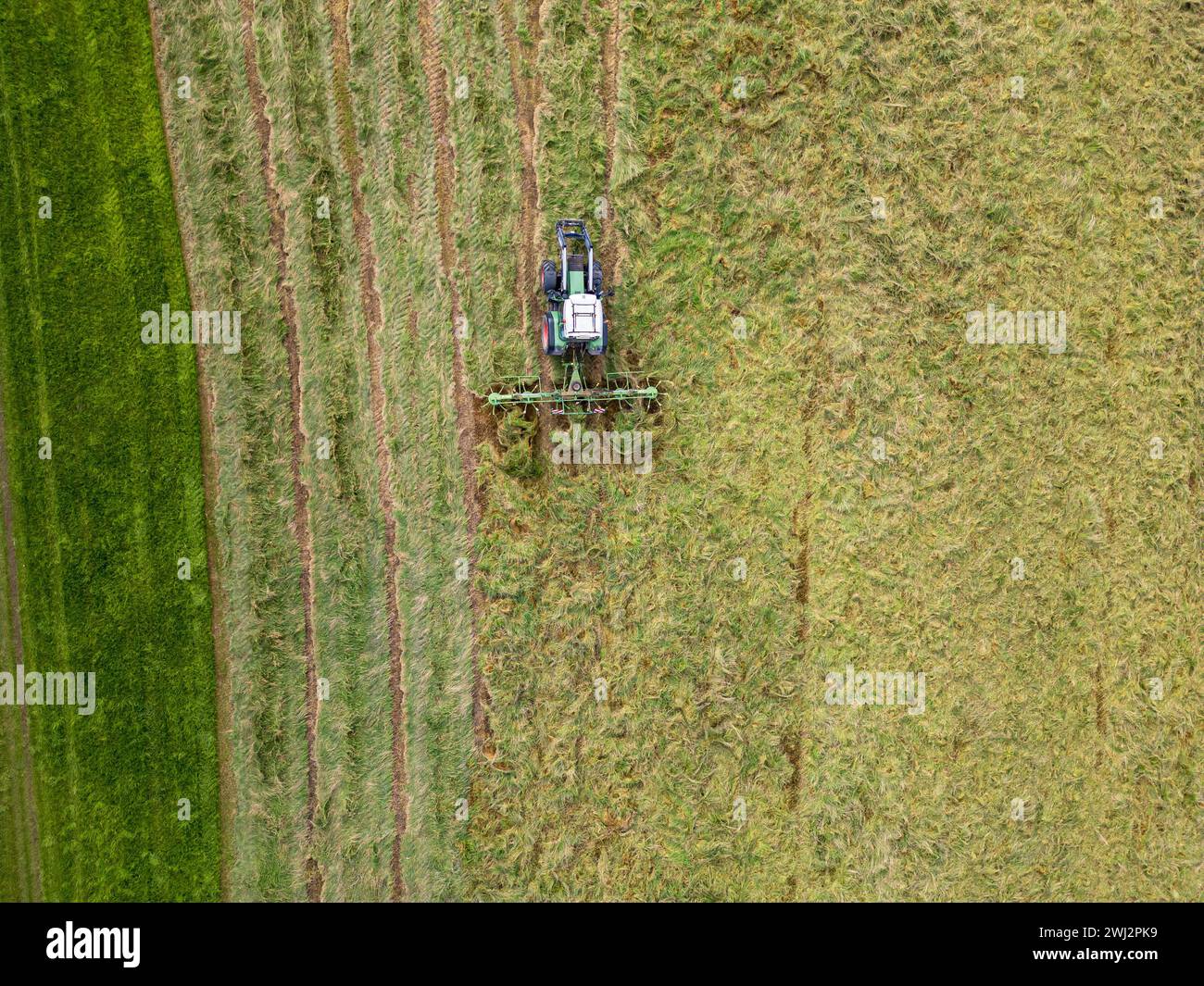 UK farming aerial photography of John Deere tractor haymaking Stock ...