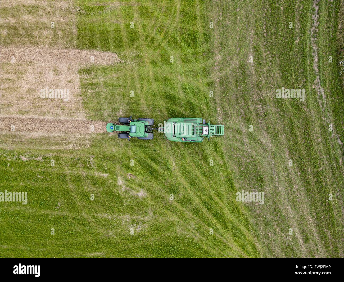 UK farming. Aerial drone photography of John Deere tractor haymaking in ...