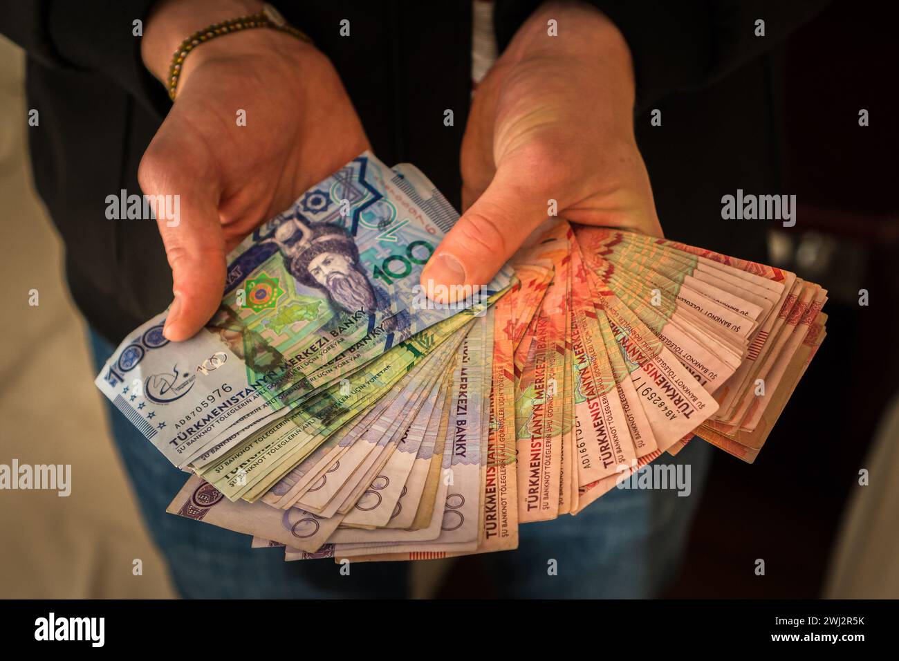 Tourist holding a collection of Turmenistan Manat exchanged for dollars ...