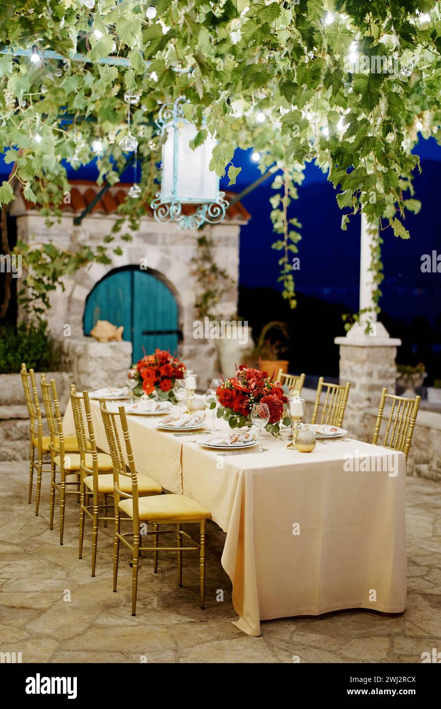 Set festive table in the courtyard of an ancient house with weaving ...