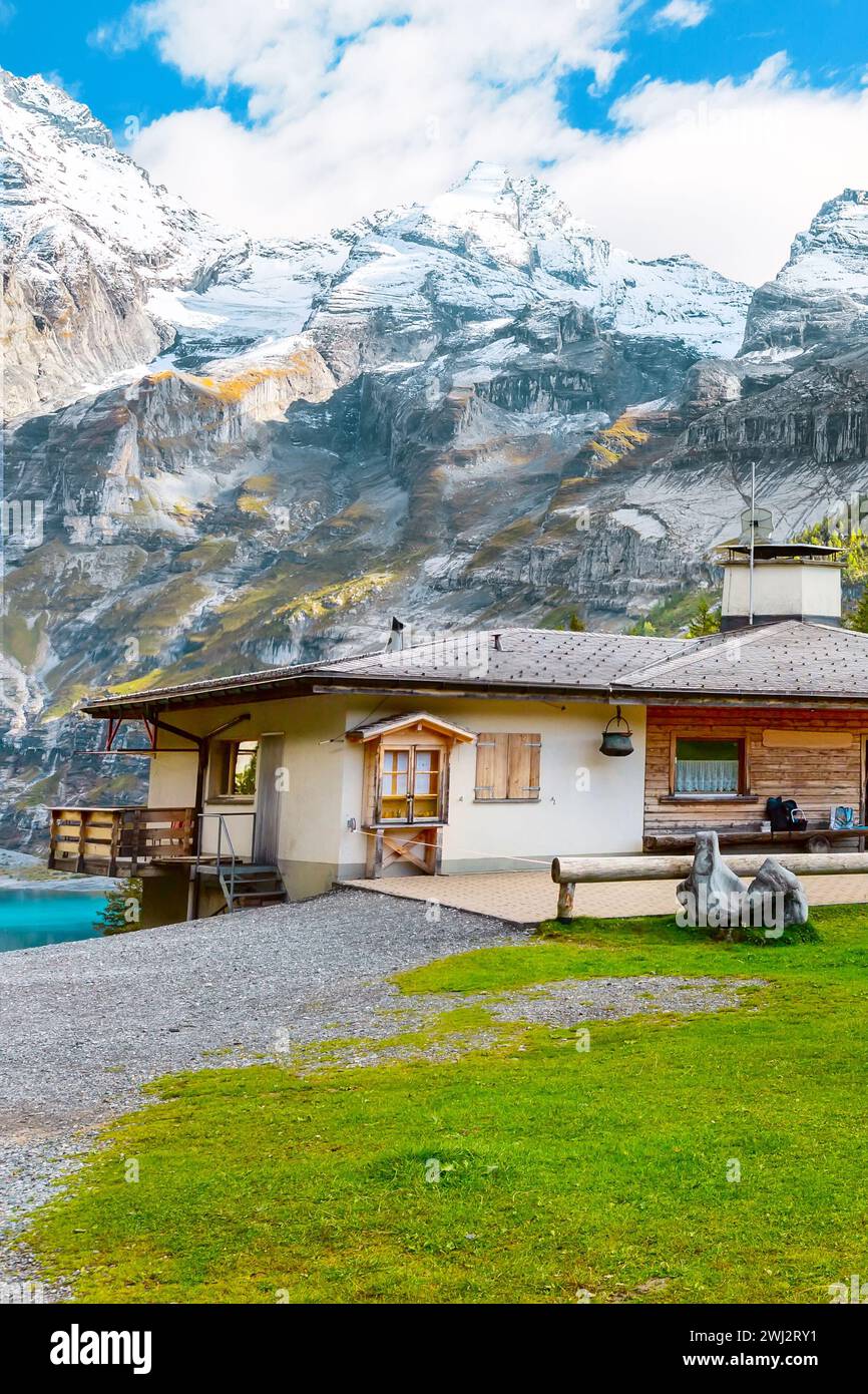 turquoise color Oeschinnensee lake and wooden chalet with Swiss Alps panorama, Berner Oberland ...