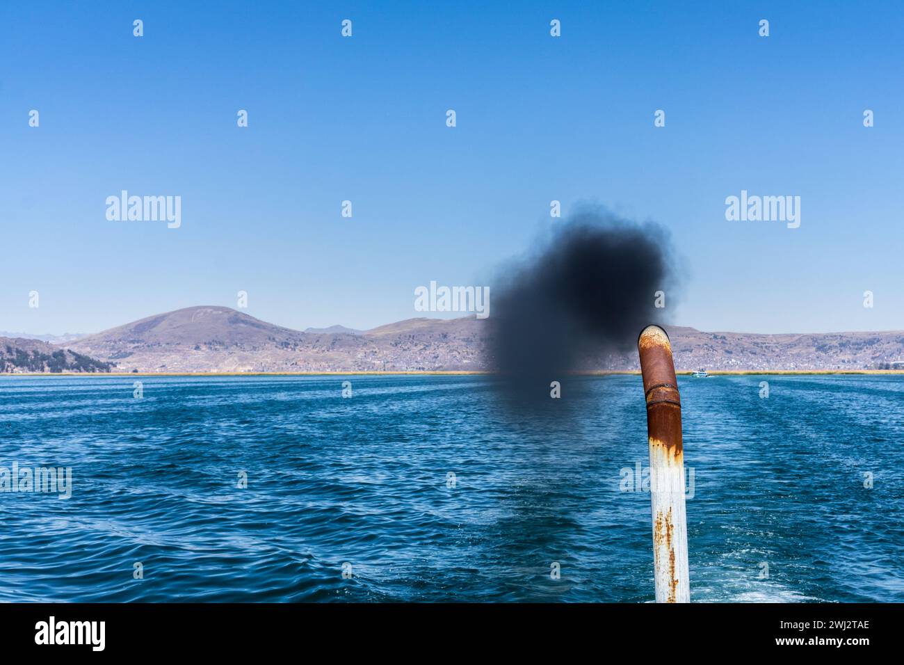 Plume a black soot coming from the tail pipe of a tourist boat on lake ...