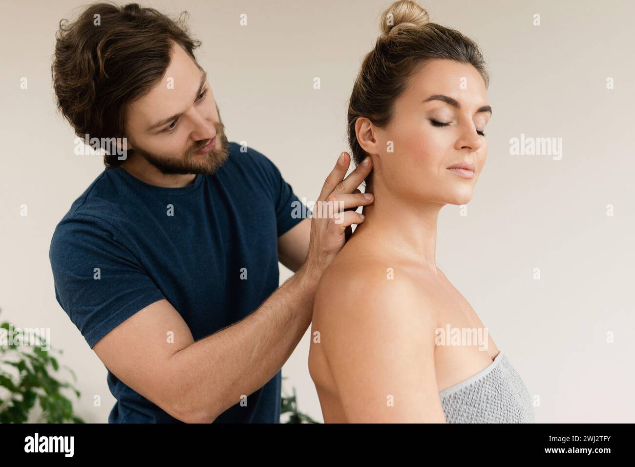 Professional masseur using acupressure techniques for client's neck ...