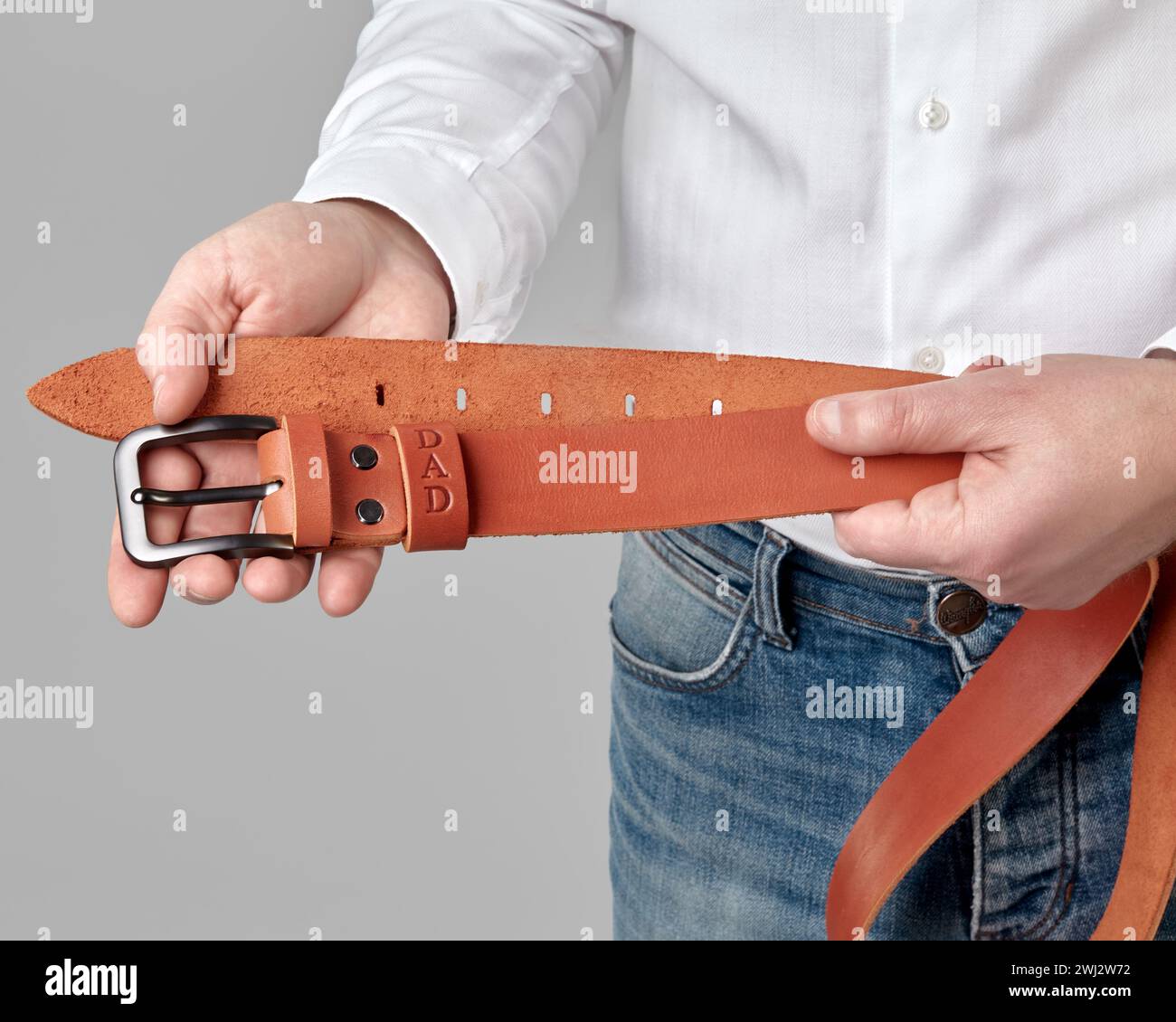 Handcrafted copper leather belt with DAD embossing in male hands Stock ...