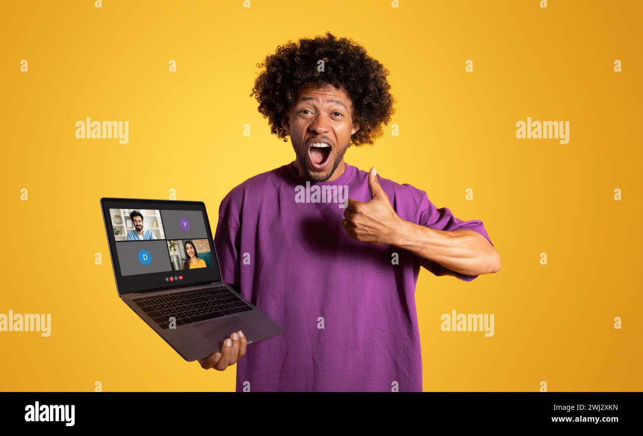 An exuberant man with curly hair gives a thumbs-up while holding a ...