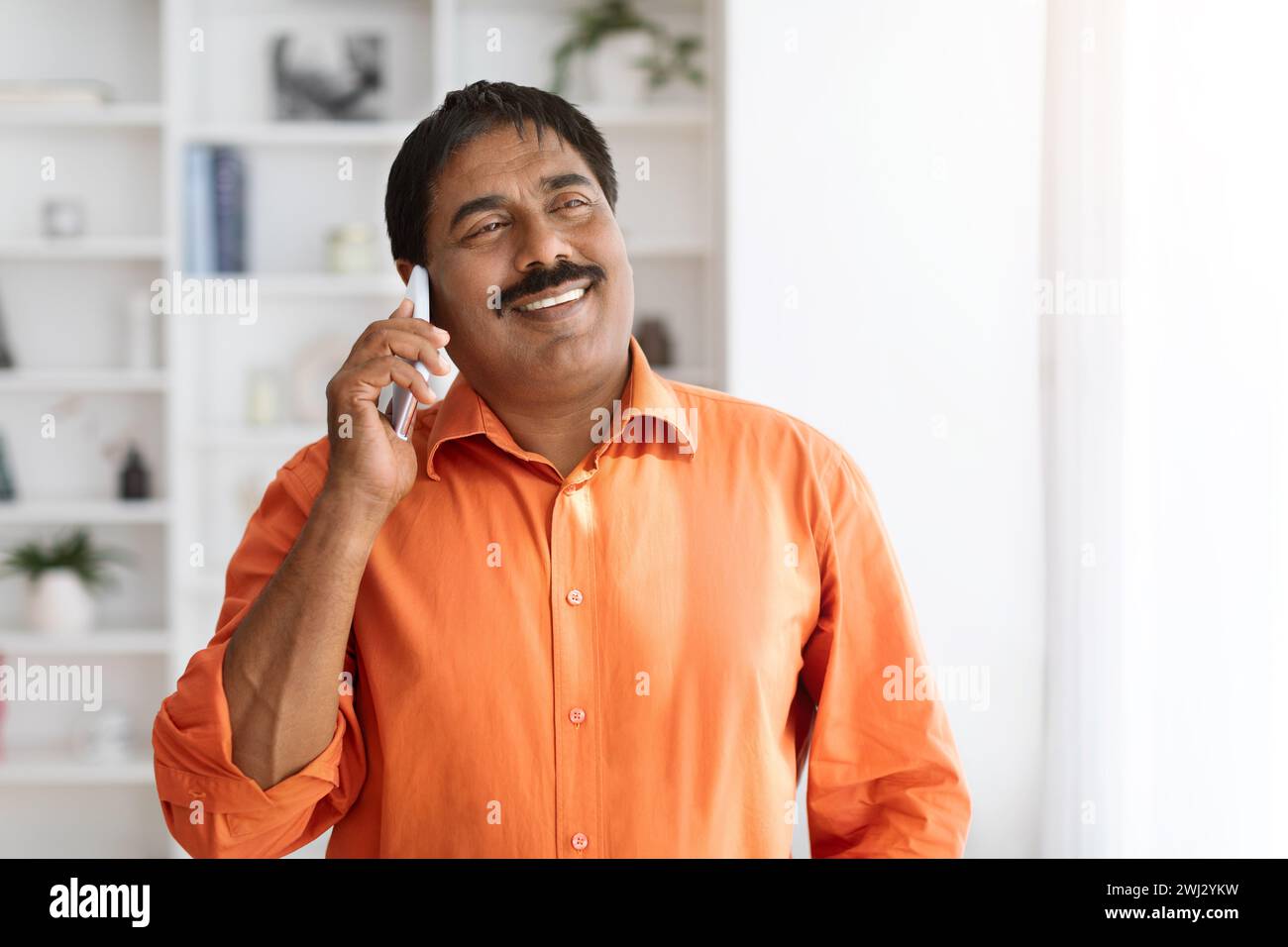 Cheerful mature indian man have phone conversation at home office Stock ...