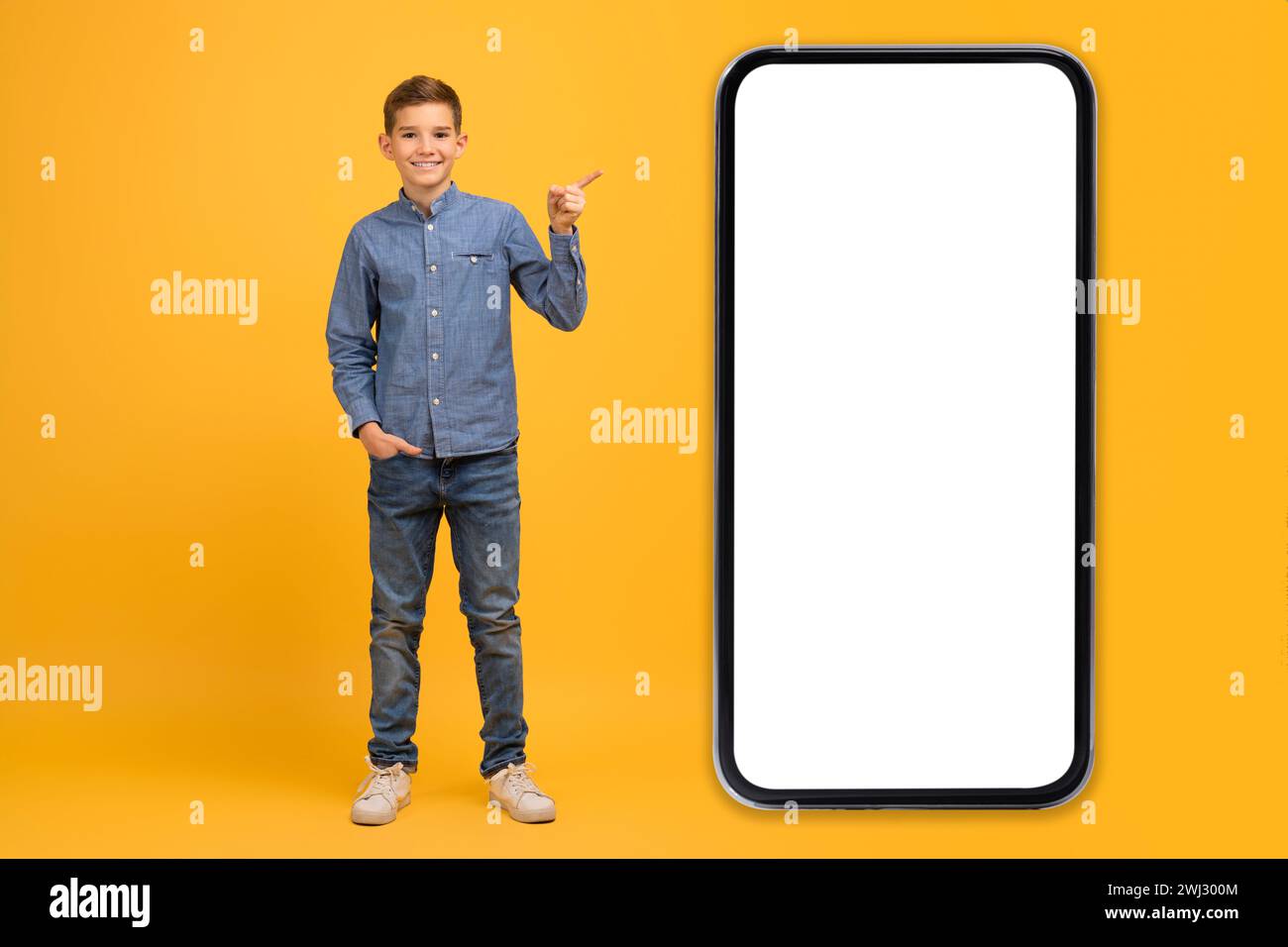 Check This. Happy teen boy pointing at big smartphone with blank screen ...