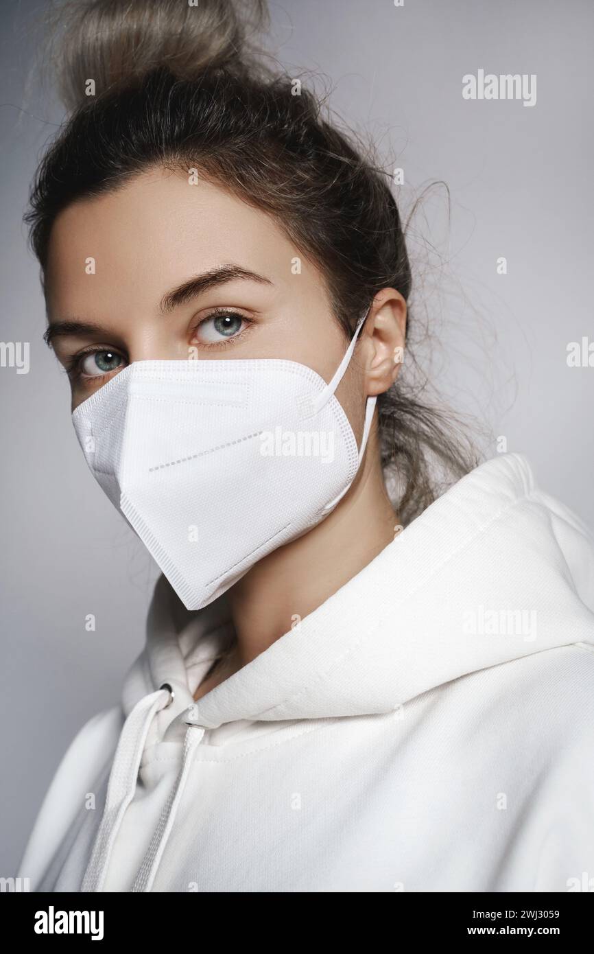 Young woman wearing white hoodie and ffp2 respirator mask Stock Photo ...