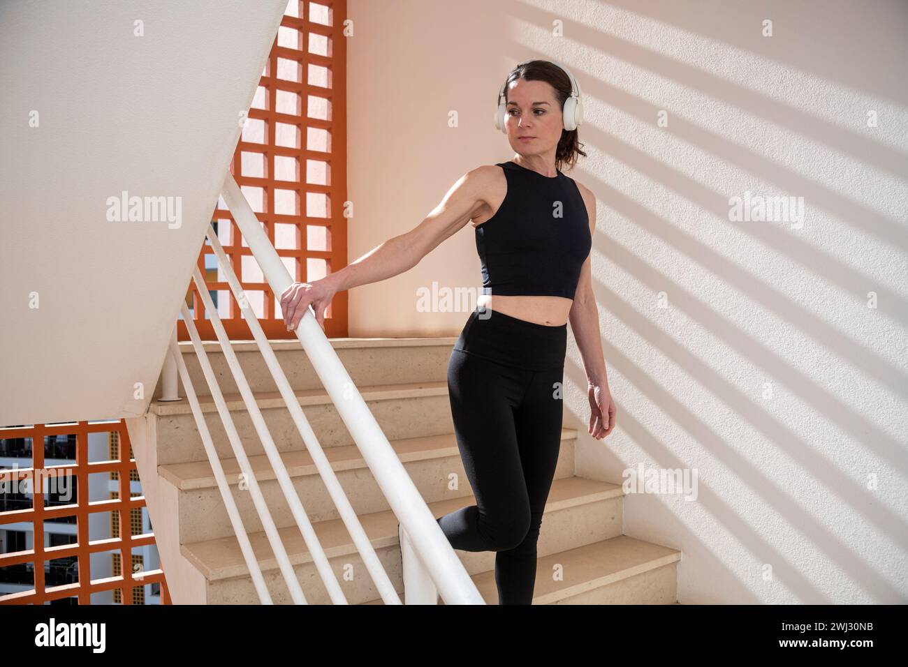 fit sporty woman in sports clothing walking down stairs. Step exercise ...
