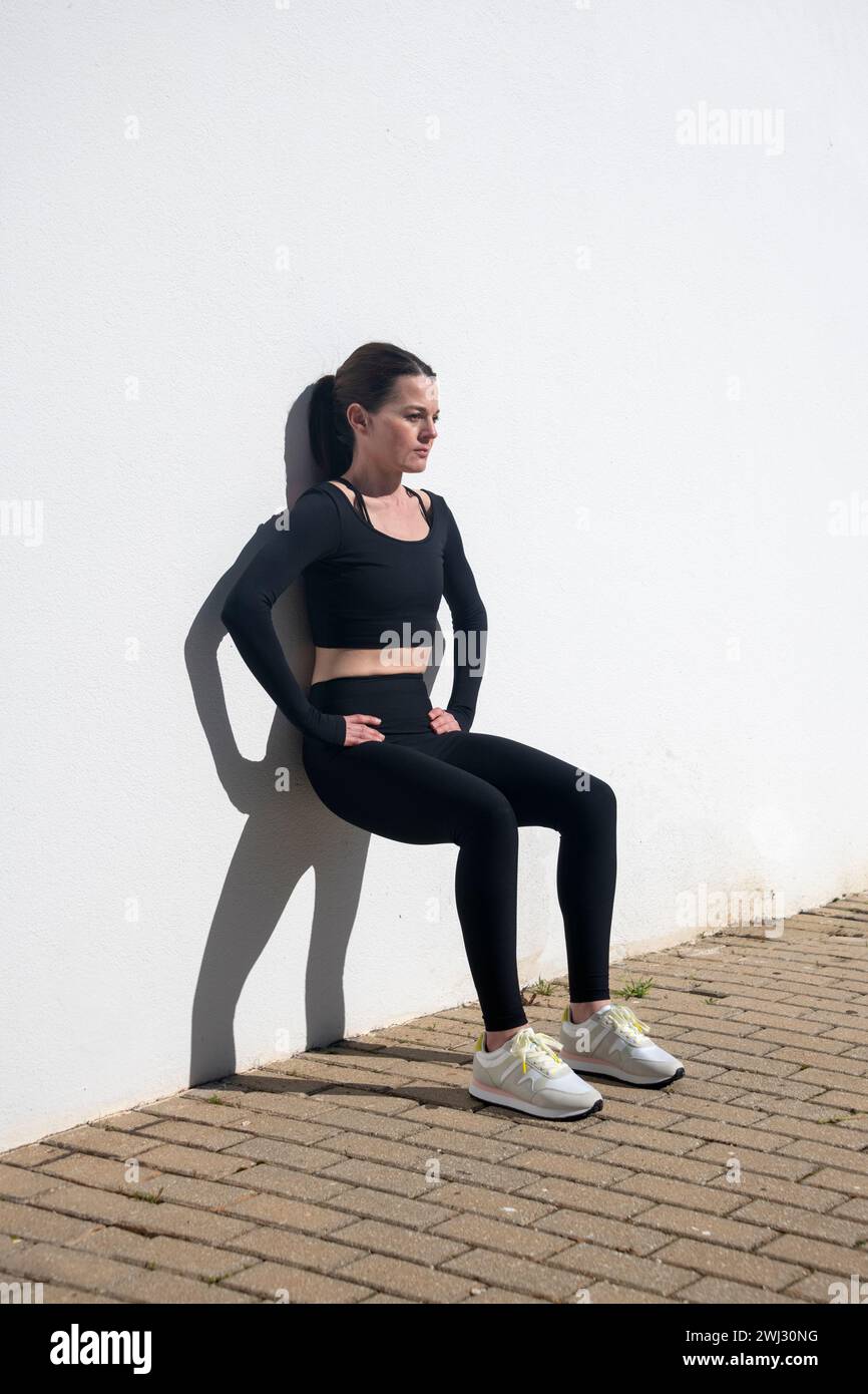 Woman and squat exercise and wall hi-res stock photography and images ...