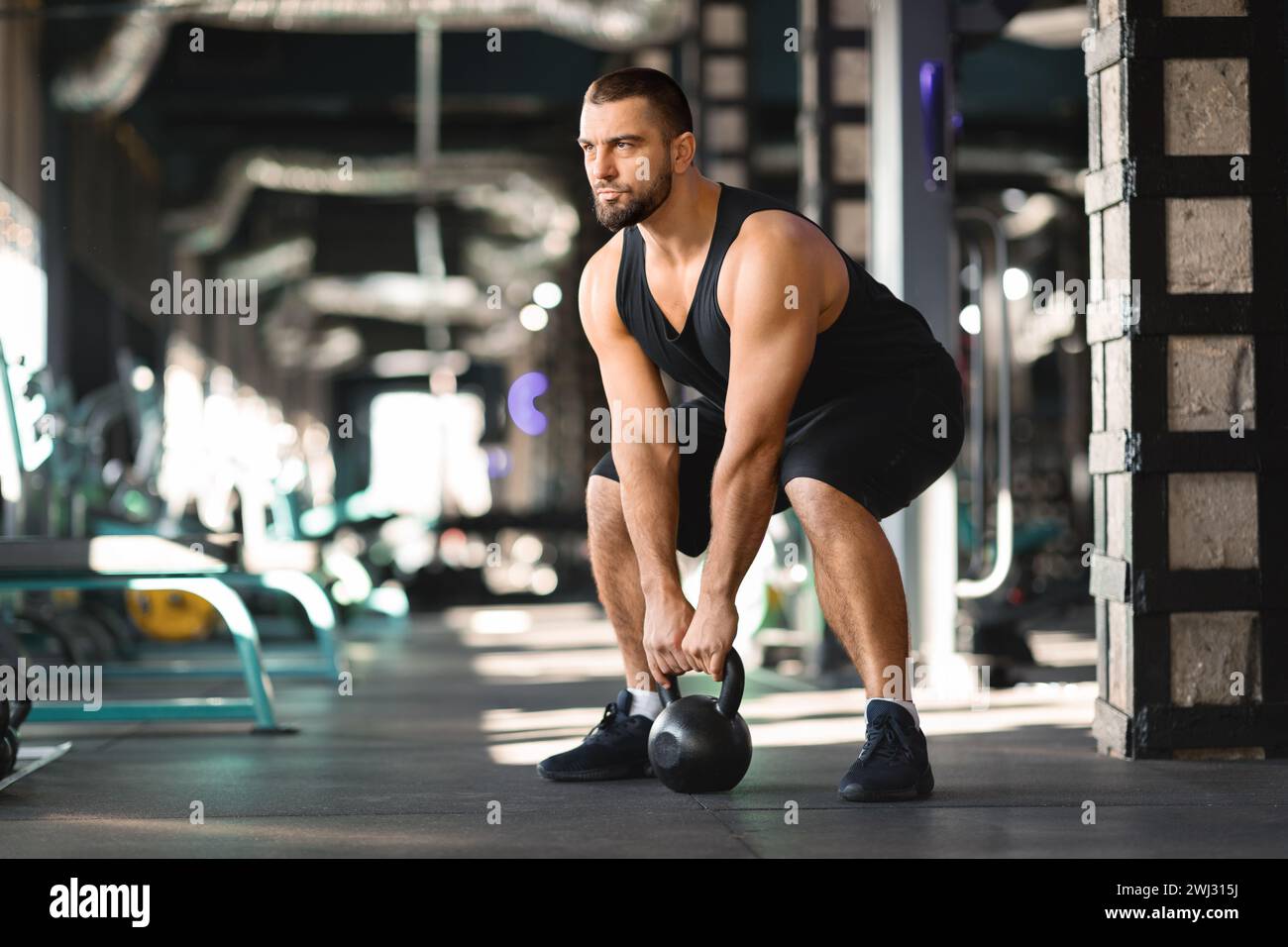 Motivated Muscular Man Training With Kettlebell At Modern Gym Interior ...