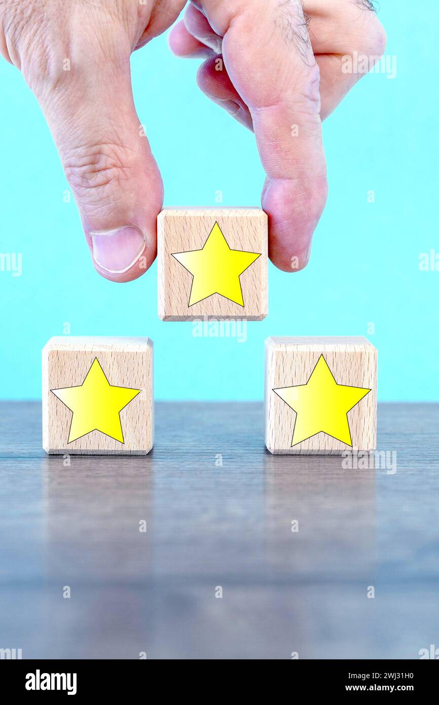 Wooden cubes with icons stars.male hand. Goal business Success ...