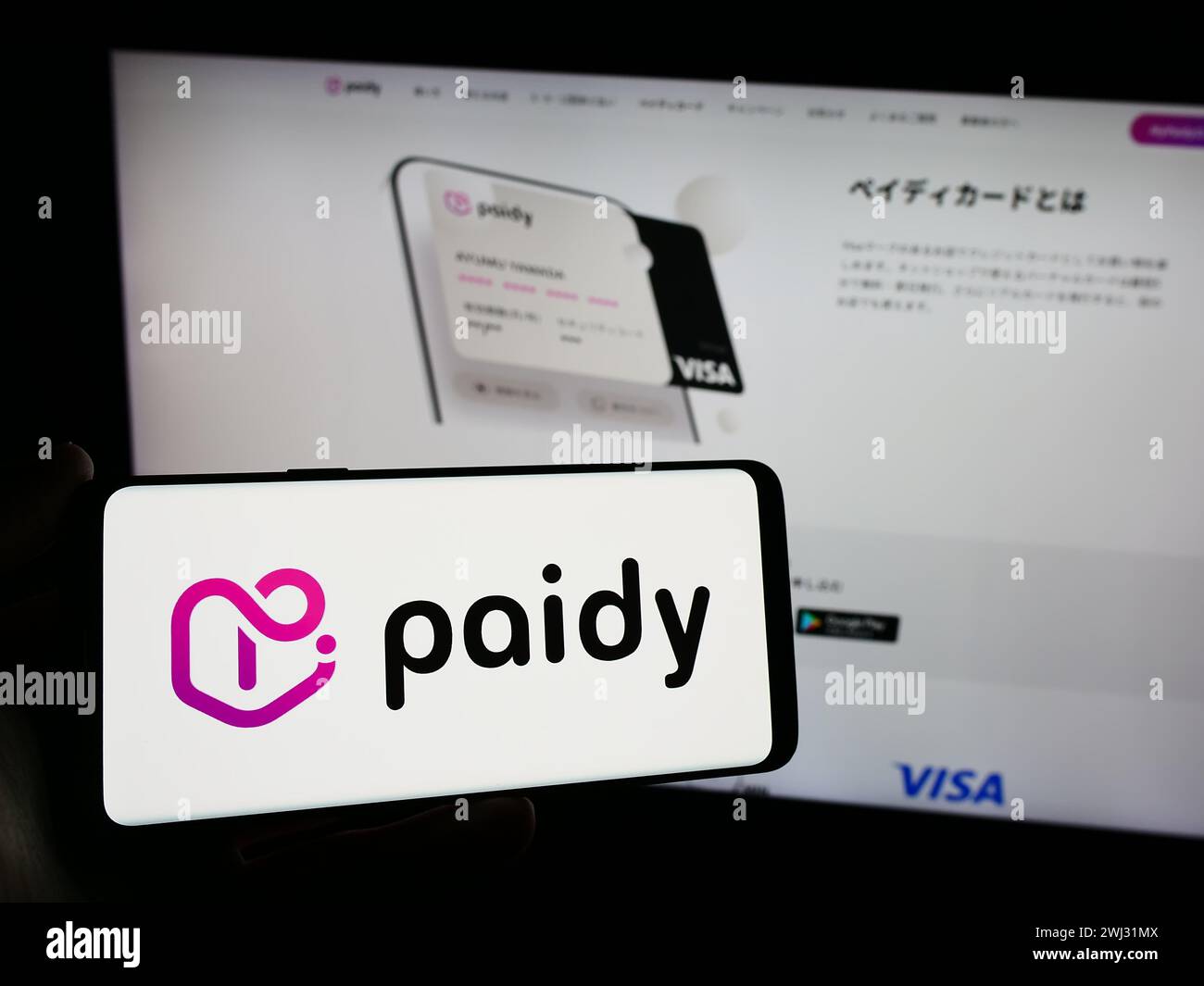 Person holding smartphone with logo of Japanese e-commerce payments ...