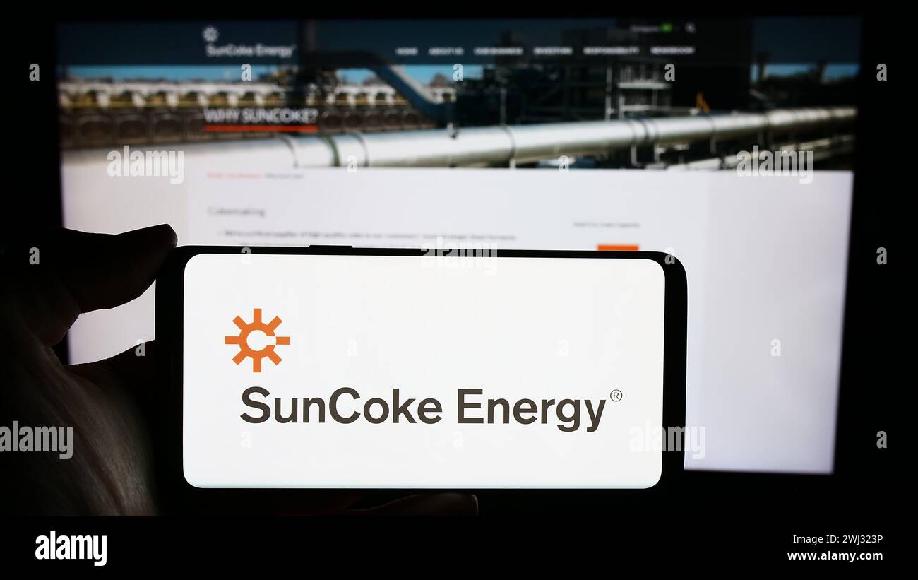 Person holding mobile phone with logo of American coke producing ...