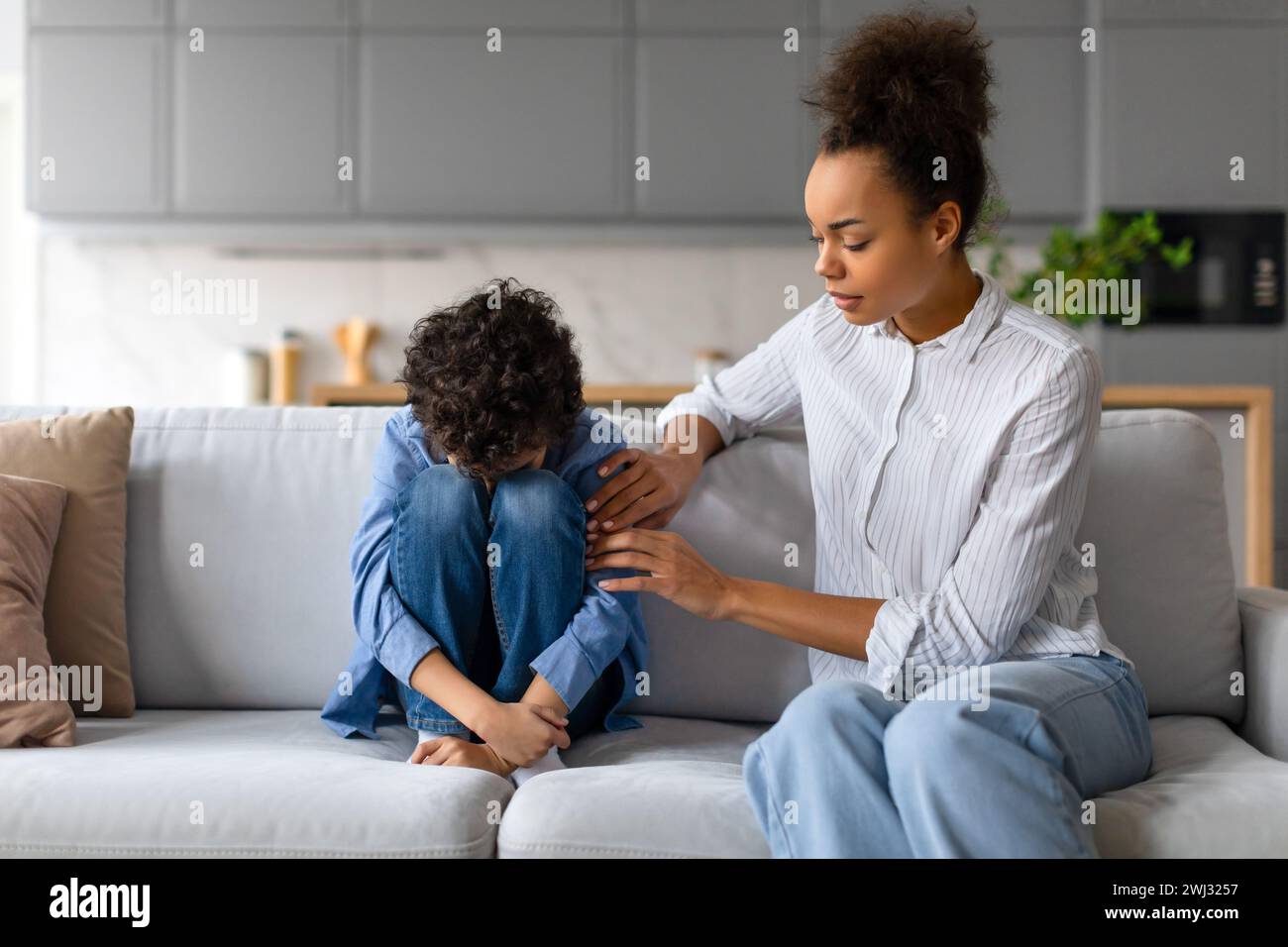 Concerned black mother comforting her sad child son at home Stock Photo ...