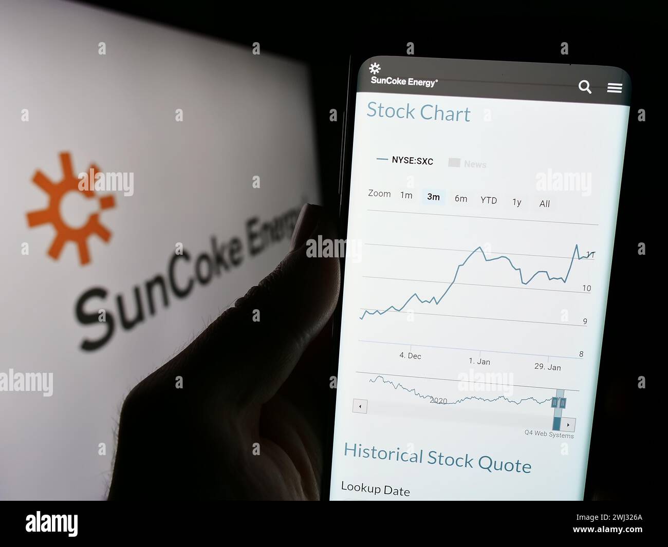 Person holding cellphone with website of US coke producing company ...