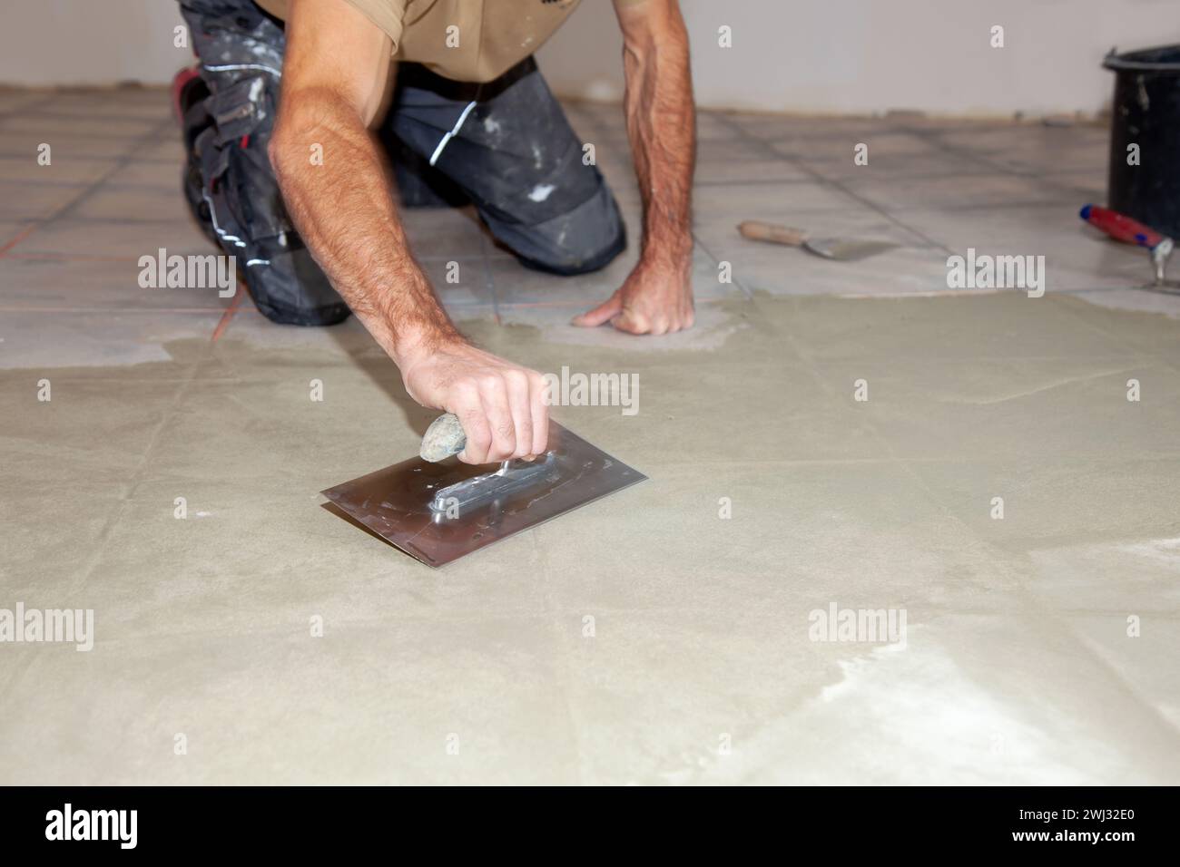 Construction worker leveling compound with putty knife. Renovation ...