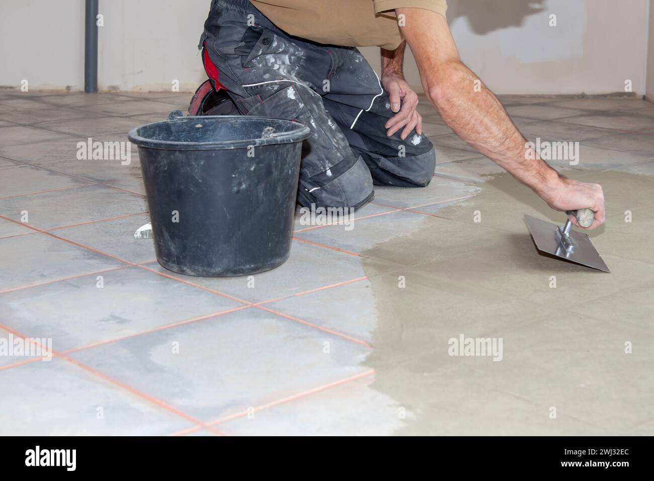 Construction worker leveling compound with putty knife. Renovation ...