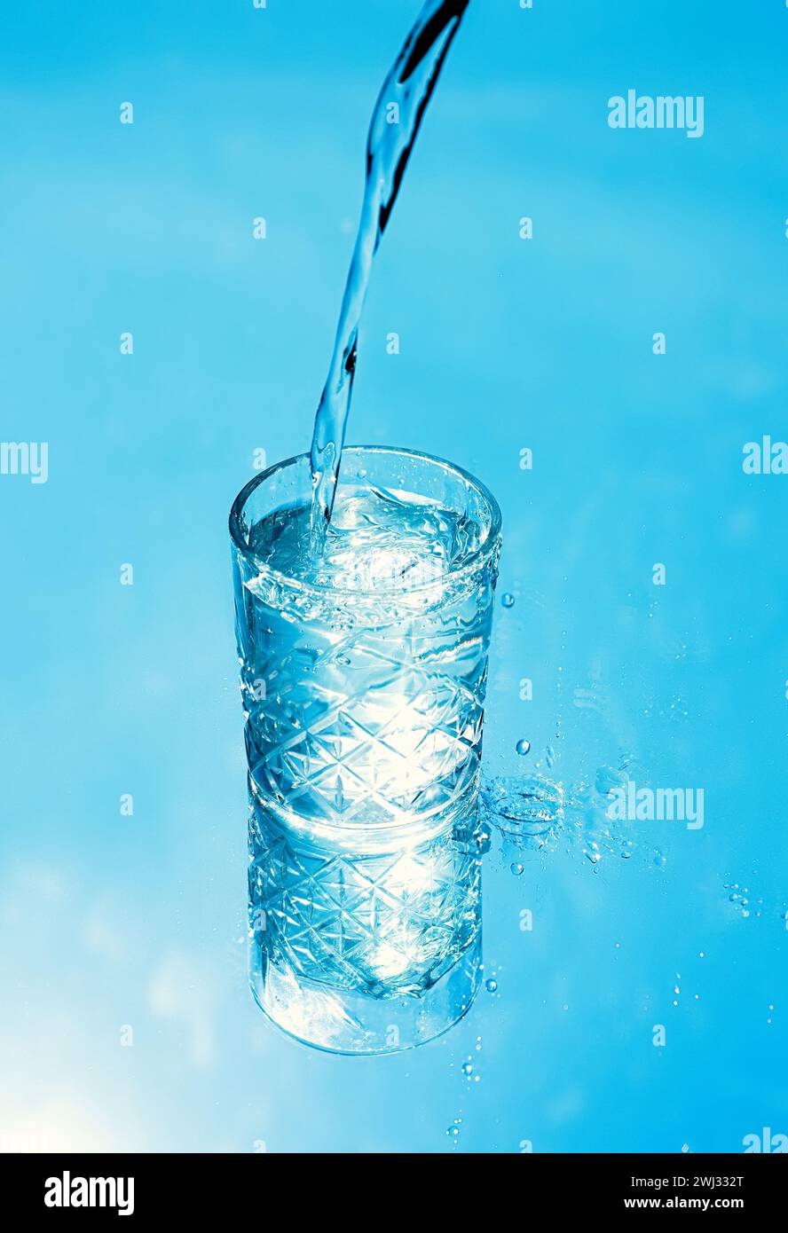 Hydration Blue water in glass with drops and splashes on transparent ...