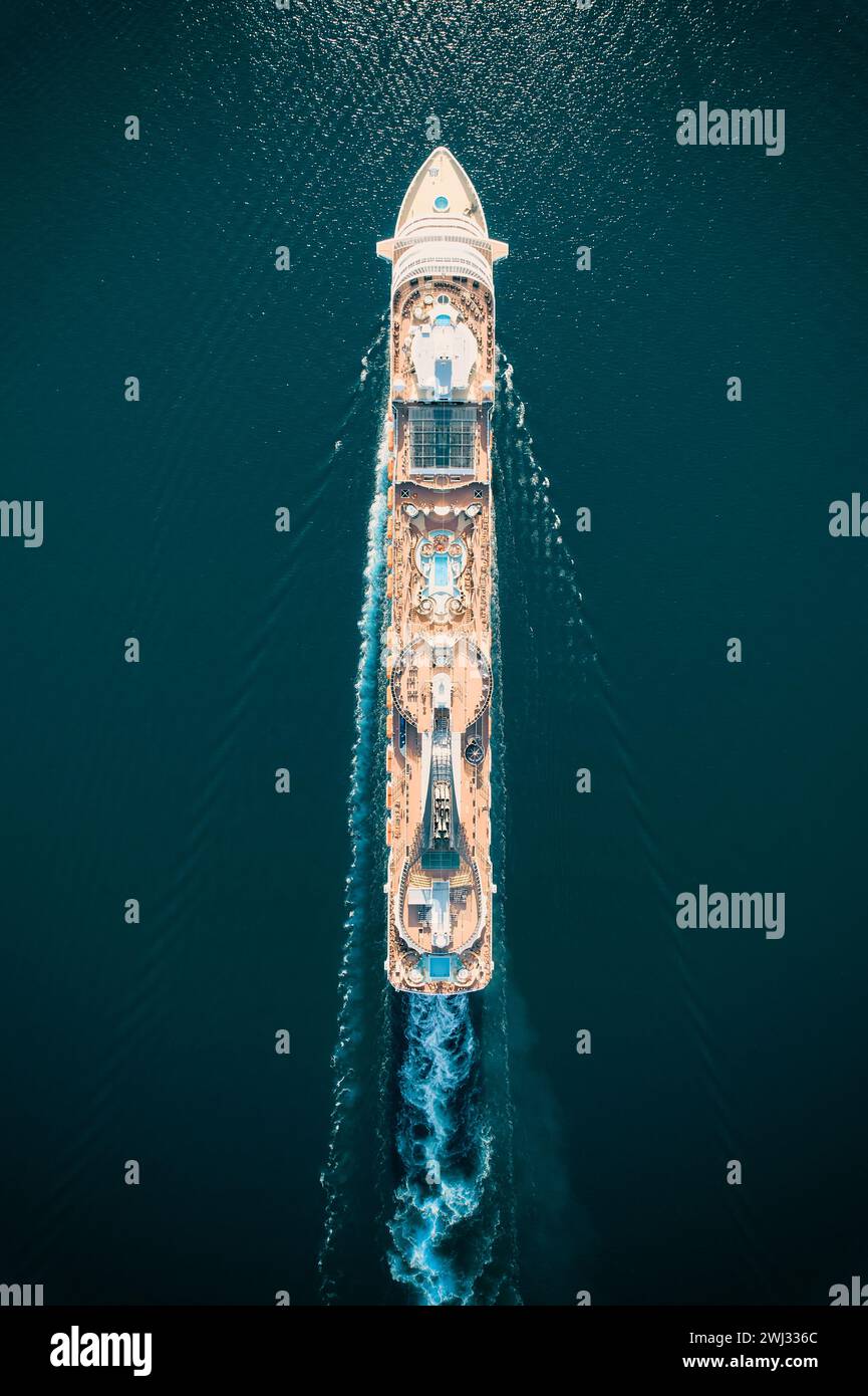 Huge cruise ship with a swimming pools floats on the sea. Top view ...