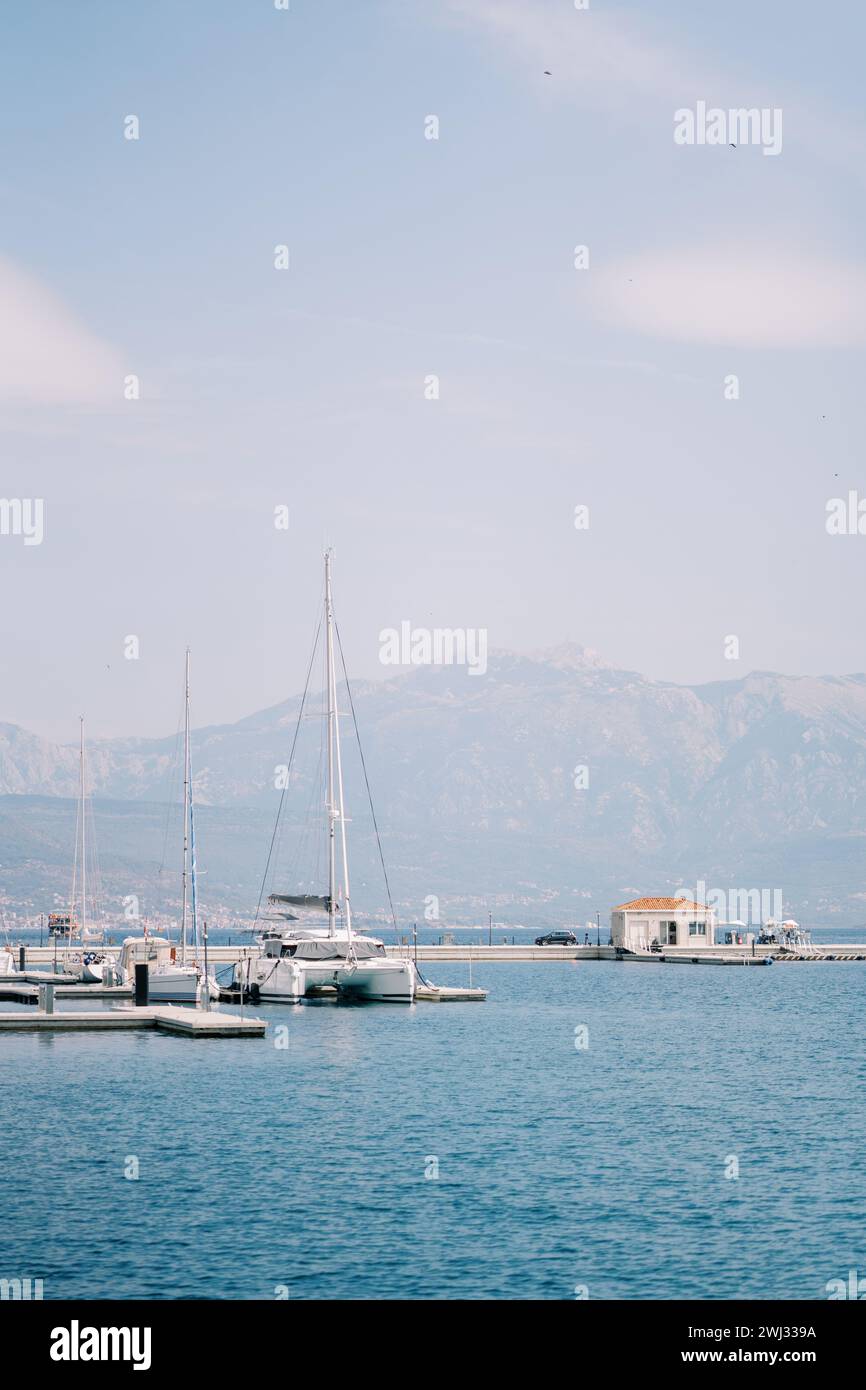 Sailing catamaran stands at the pier in the sea against the backdrop of ...