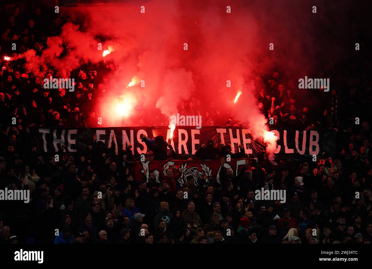 Crystal Palace fans hold up a protest banner and set off flares during ...