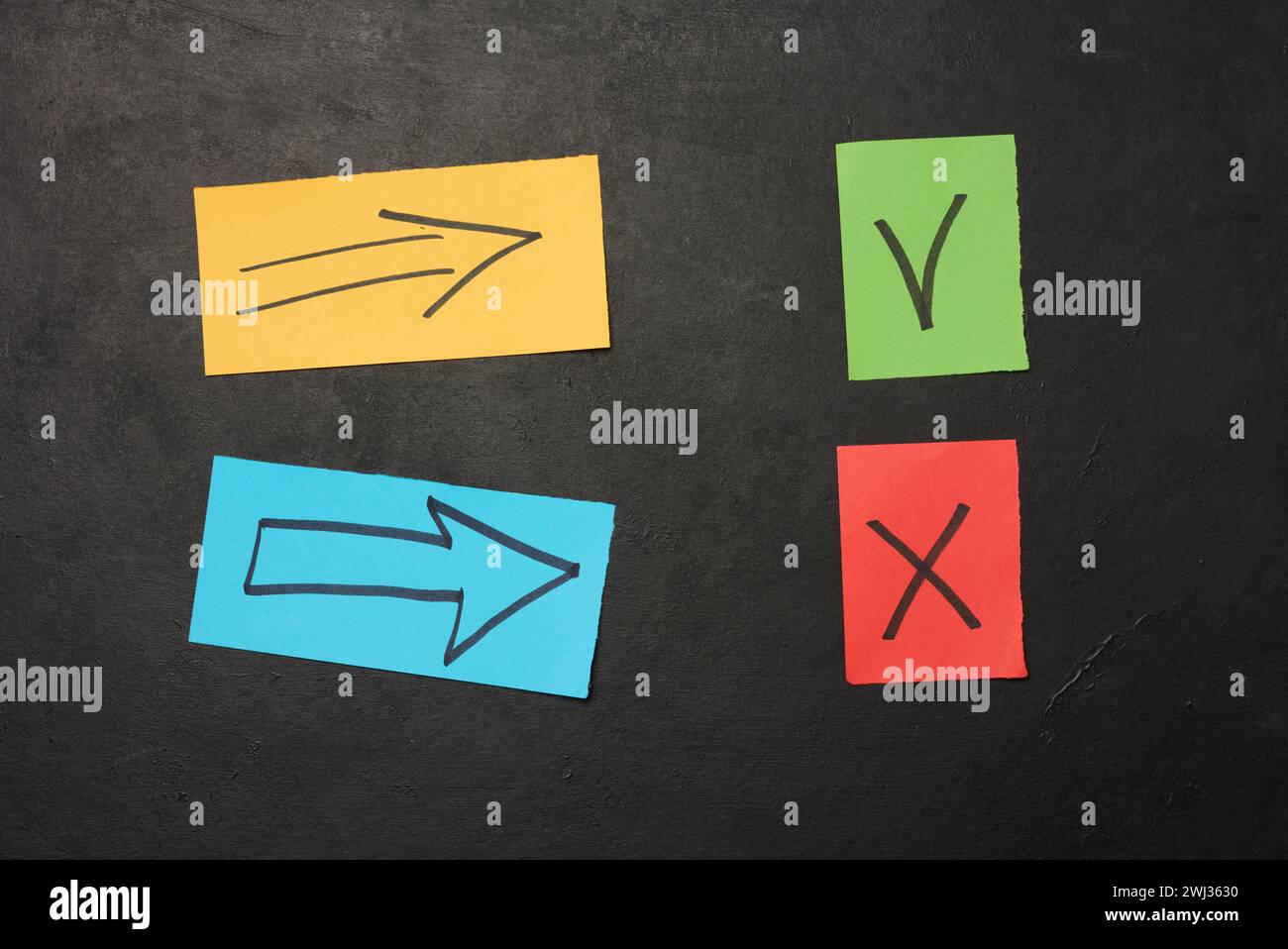 Two paper sheets with drawn check mark and cross symbols, representing ...