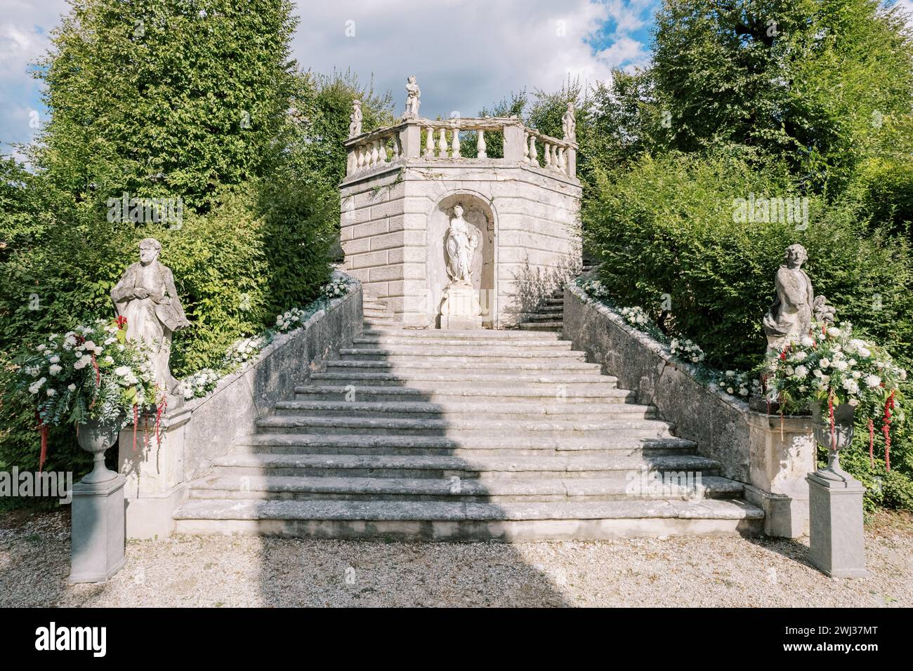 Bouquets of flowers in antique stone vases and along the handrail of ...