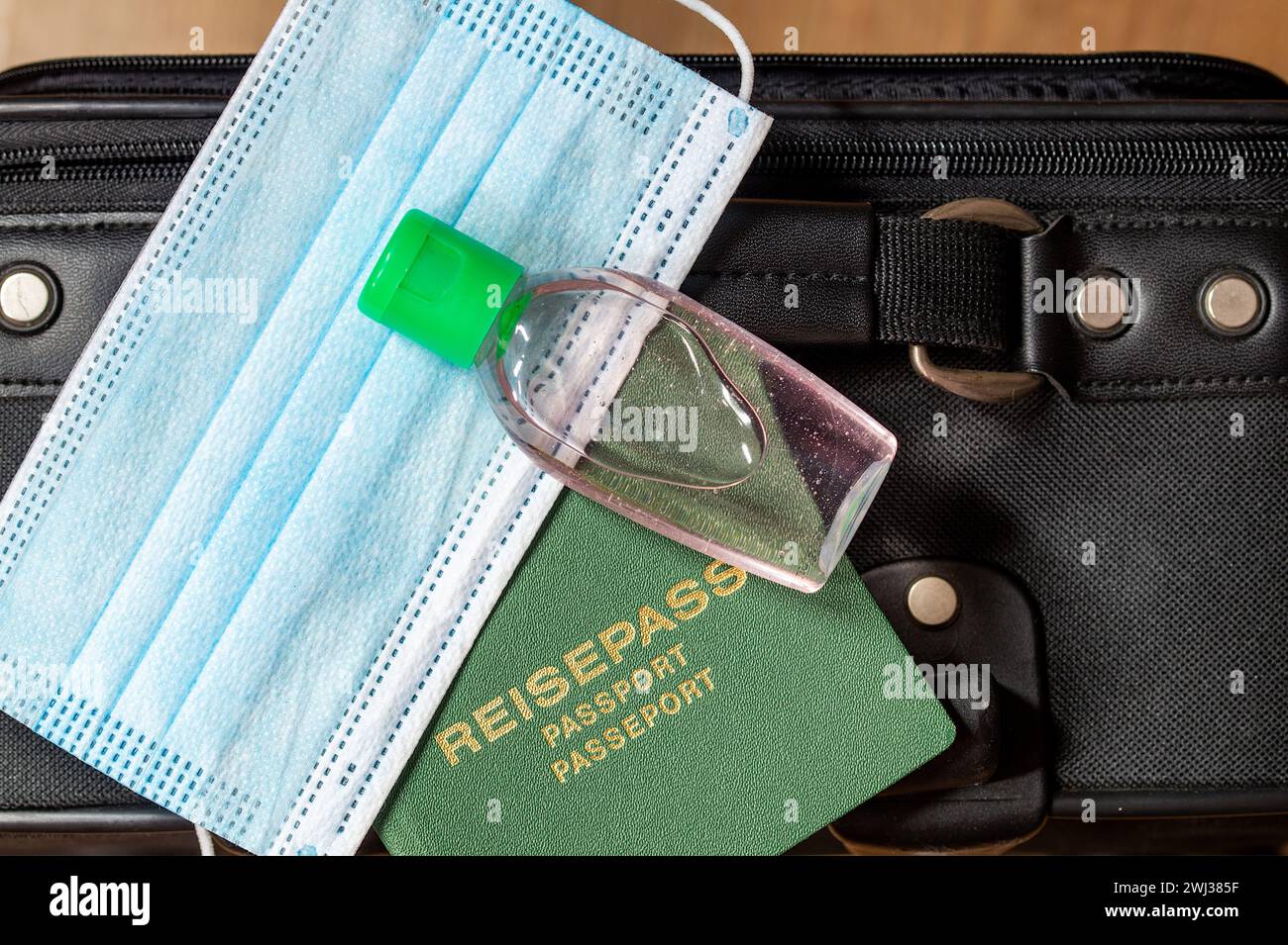 German Passport, disposable mask, bottle of hand sanitizer ...