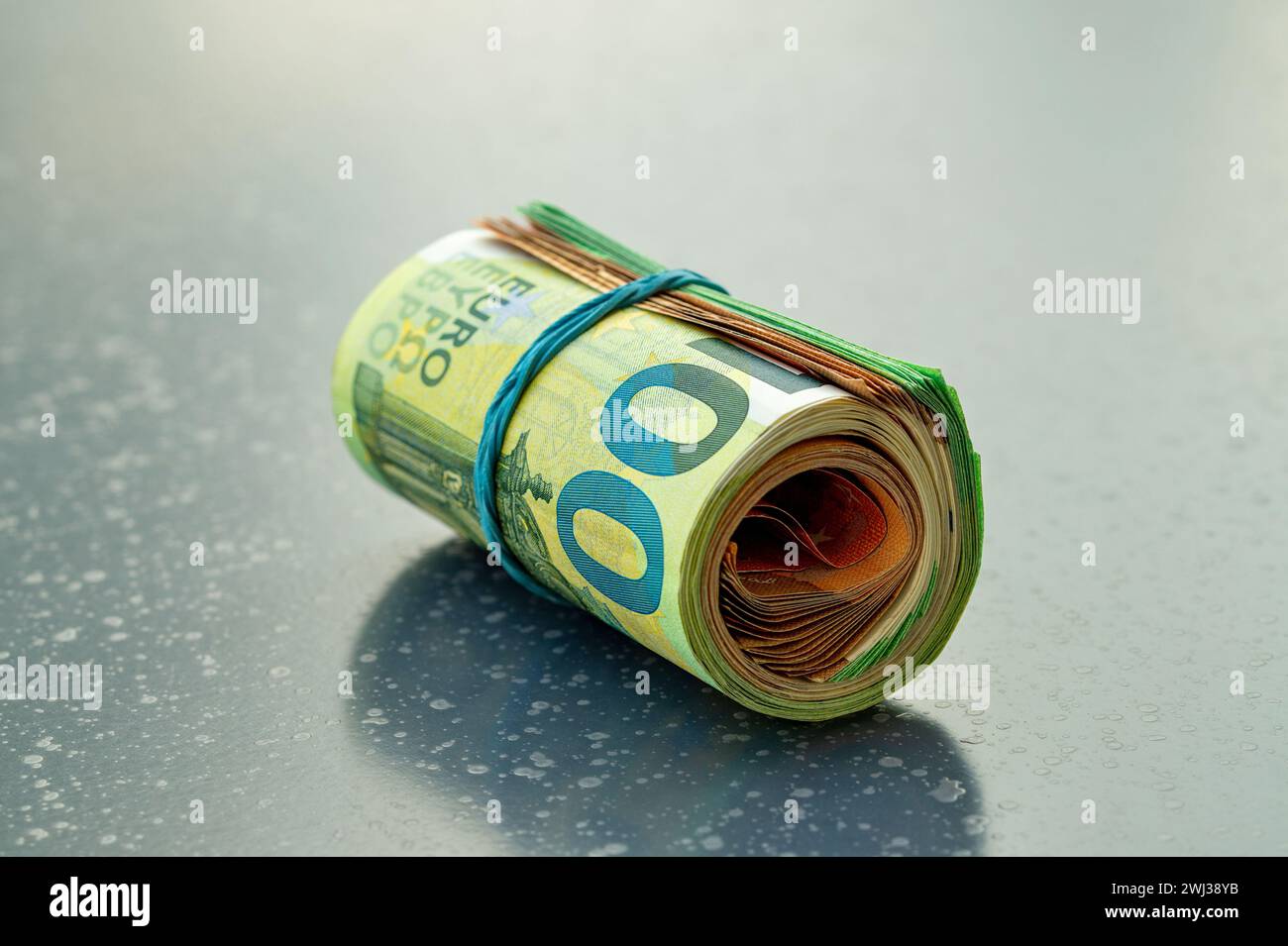 Money roll Euro isolated on a dark table. 100 and 50 Euro bills twisted ...