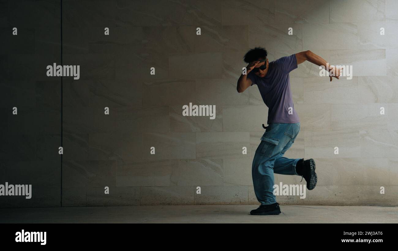 Skilled smart street dancer practice b-boy movement in building with ...