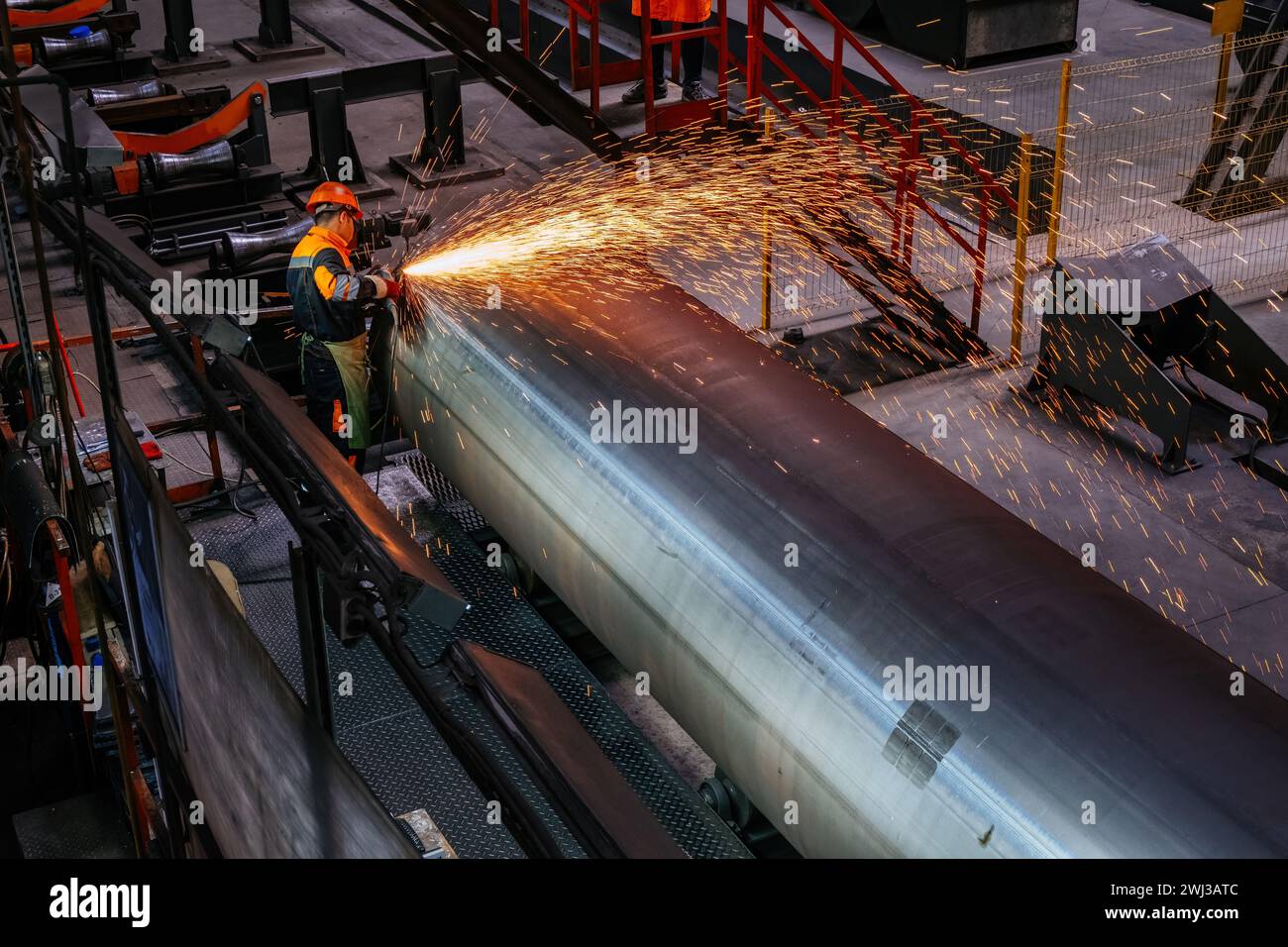Worker cleans welded seam on steel pipe using grinding machine Stock ...