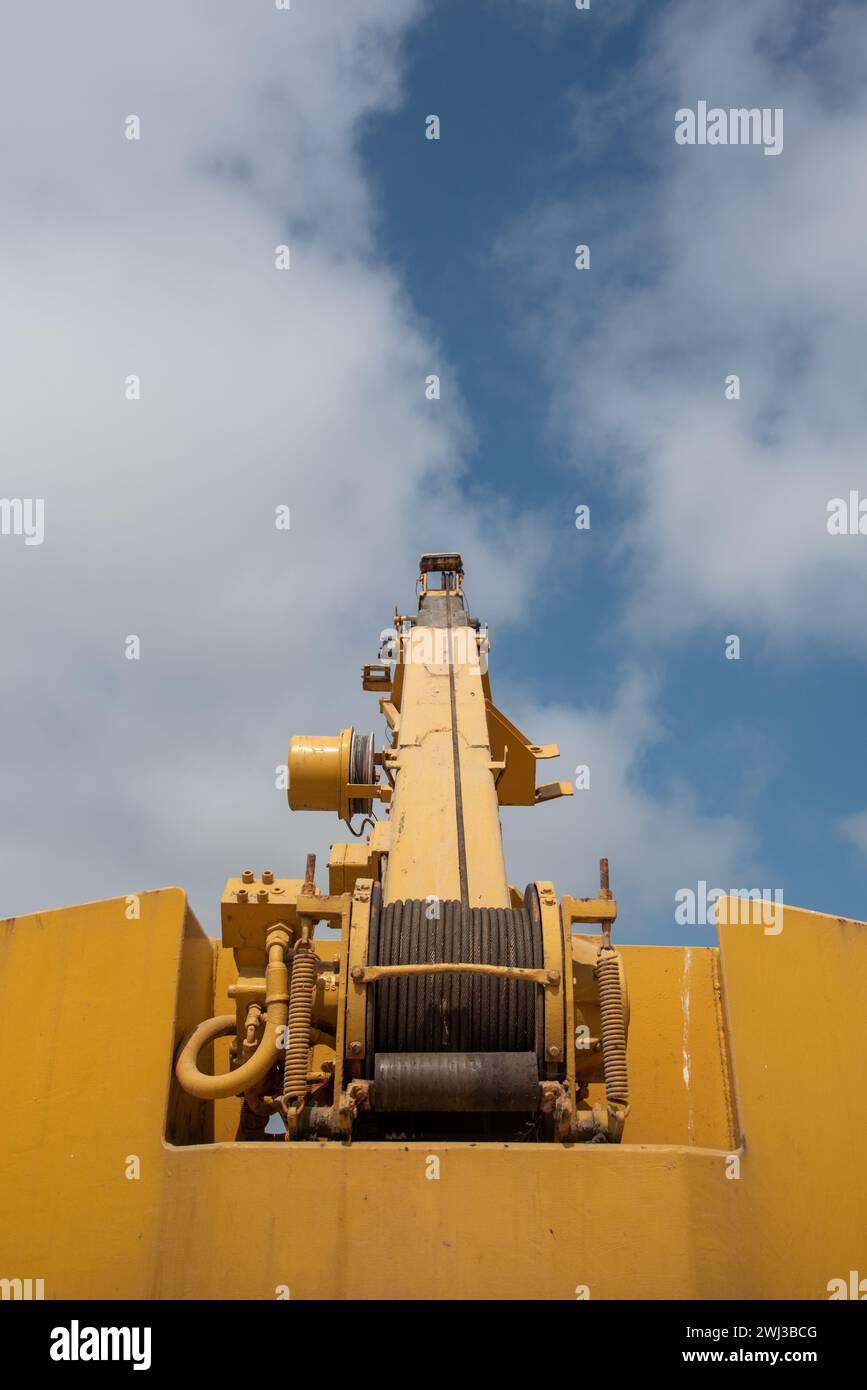Details of a yellow industrial crane against blue cloud sky. Heave duty ...
