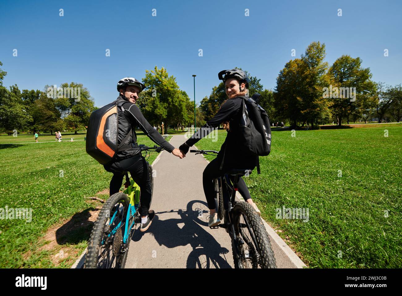 A sweet couple, adorned in cycling gear, rides their bicycles, their ...