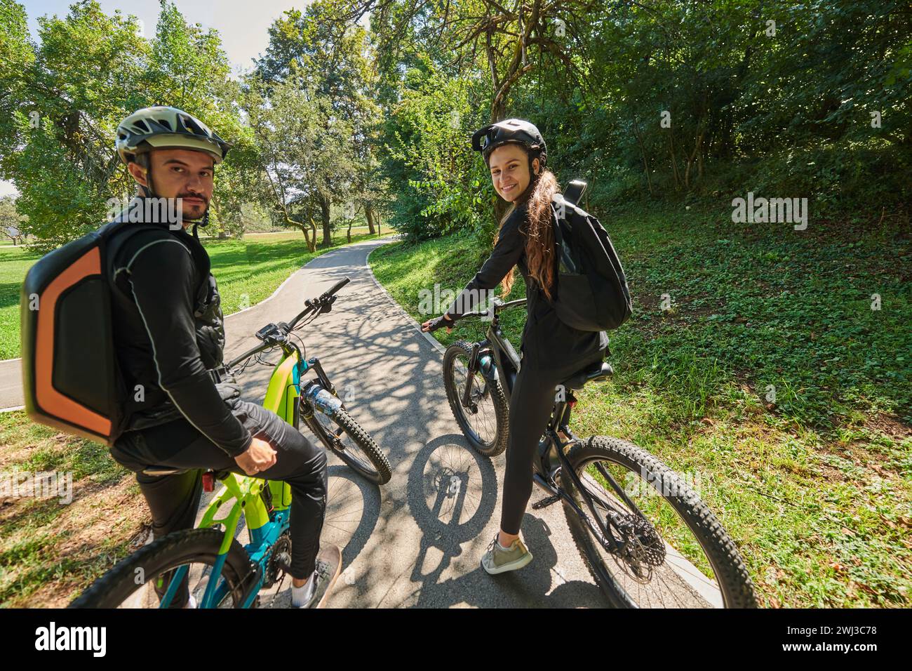 A sweet couple, adorned in cycling gear, rides their bicycles, their ...