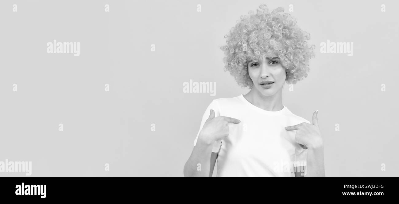 self confident freaky woman in curly clown wig poonting finger on ...