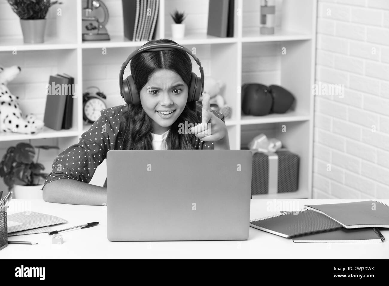 School girl student sitting at the table, using laptop when studying ...