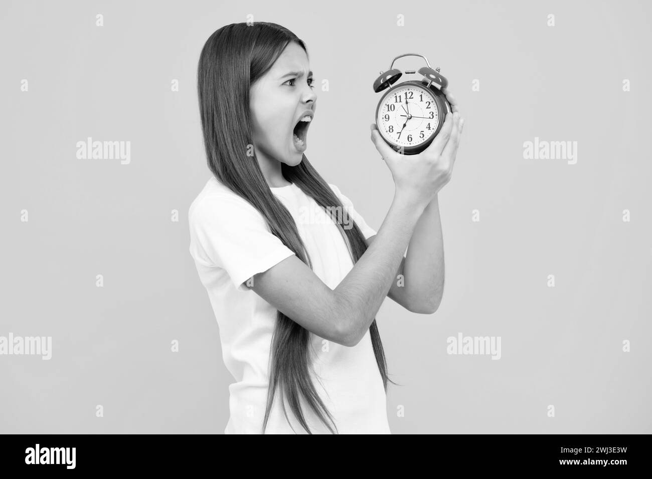Punctual teen girl checking time. Child with alarm clock showing time ...