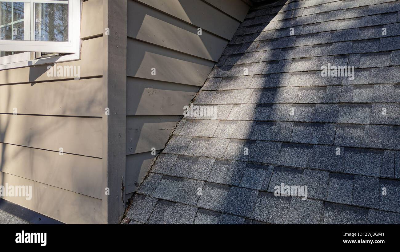 Drone view of damaged rotten wood siding along shingles due to improper ...