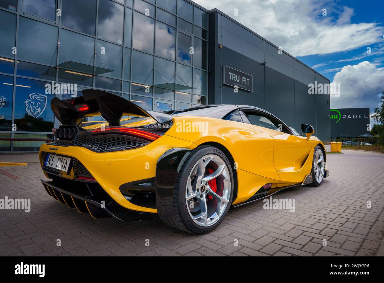 Yellow McLaren 765LT, Raised Wing, Set Against a Modern City Backdrop ...