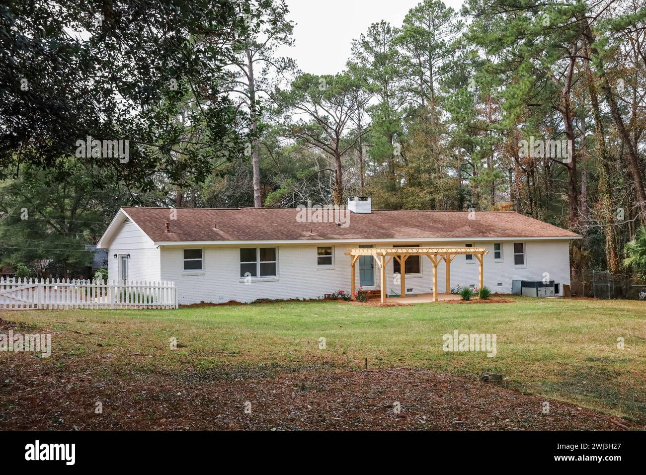 The rear back exterior of a newly painted and renovated white brick ...